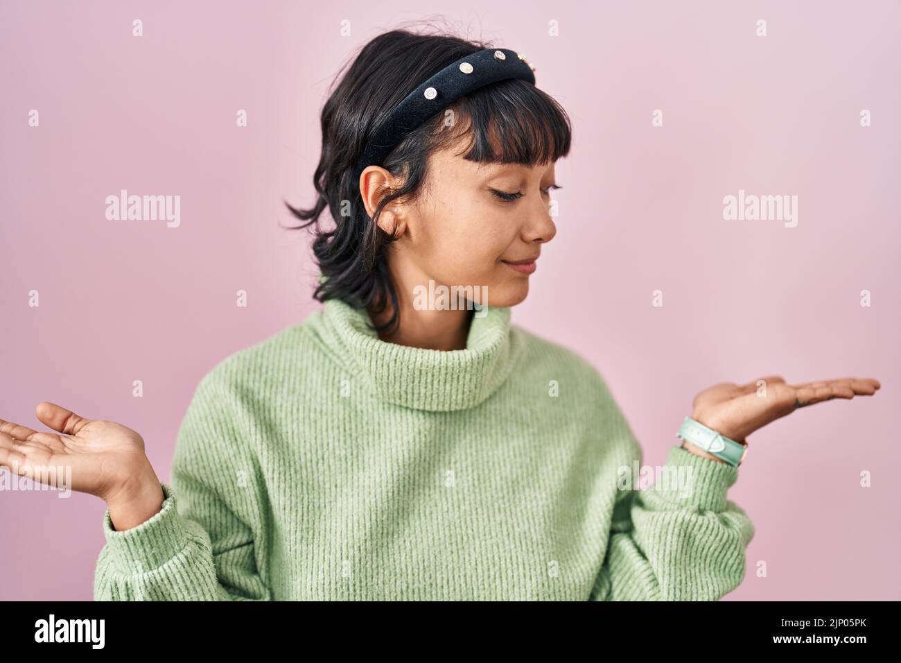 Young beautiful woman standing over pink background smiling showing ...