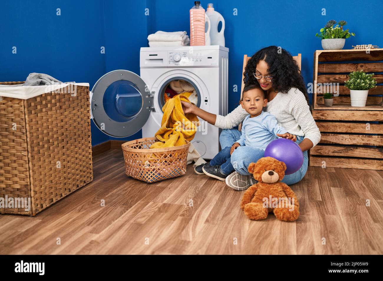 Mother and son smiling confident washing clothes at laundry room Stock ...