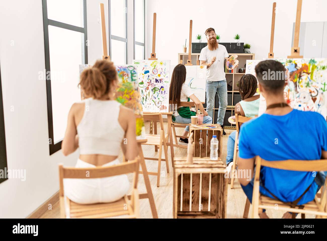 Group of people smiling happy drawing in paint class at art studio ...