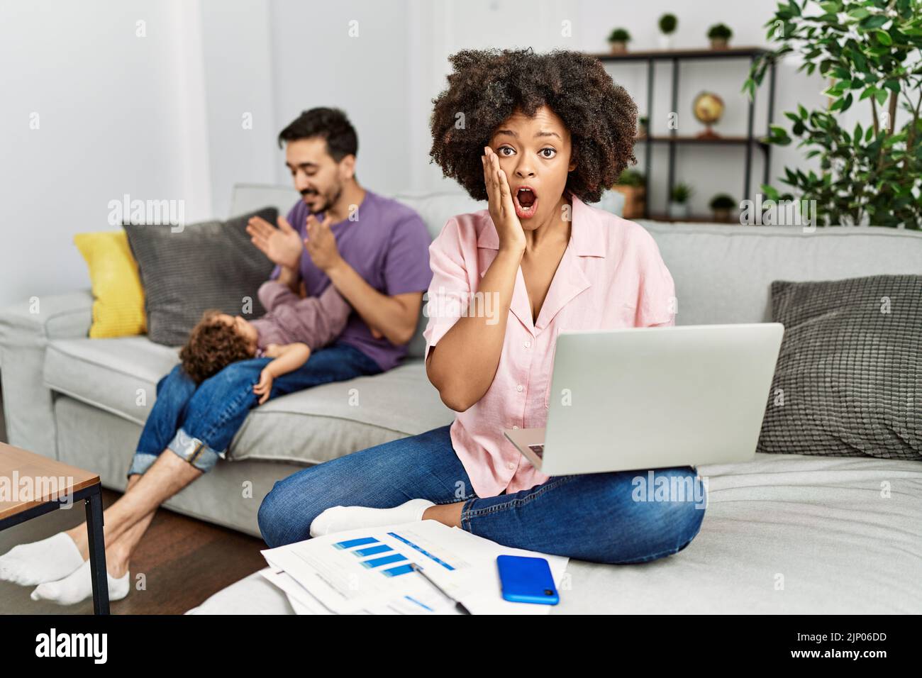 Mother of interracial family working using computer laptop at home ...
