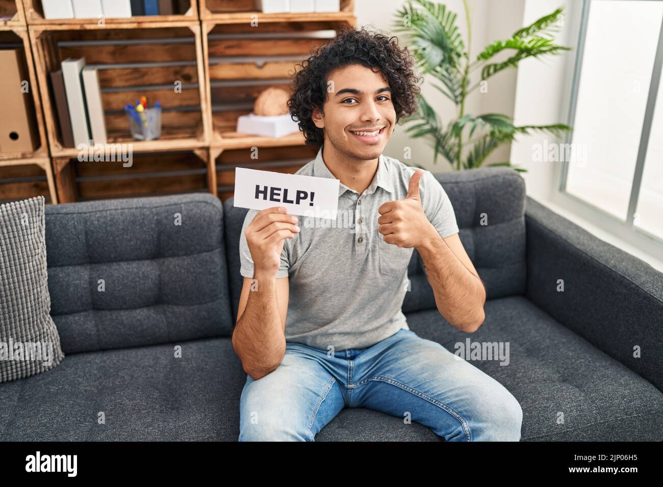 Hispanic man with curly hair asking for help smiling happy and positive ...