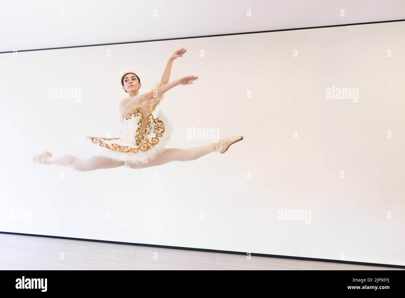 A young charming ballerina does ballet exercises in a jump in the ...