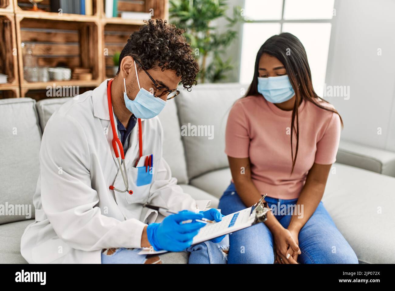 Young doctor man reading patient checklist report sitting on the sofa ...