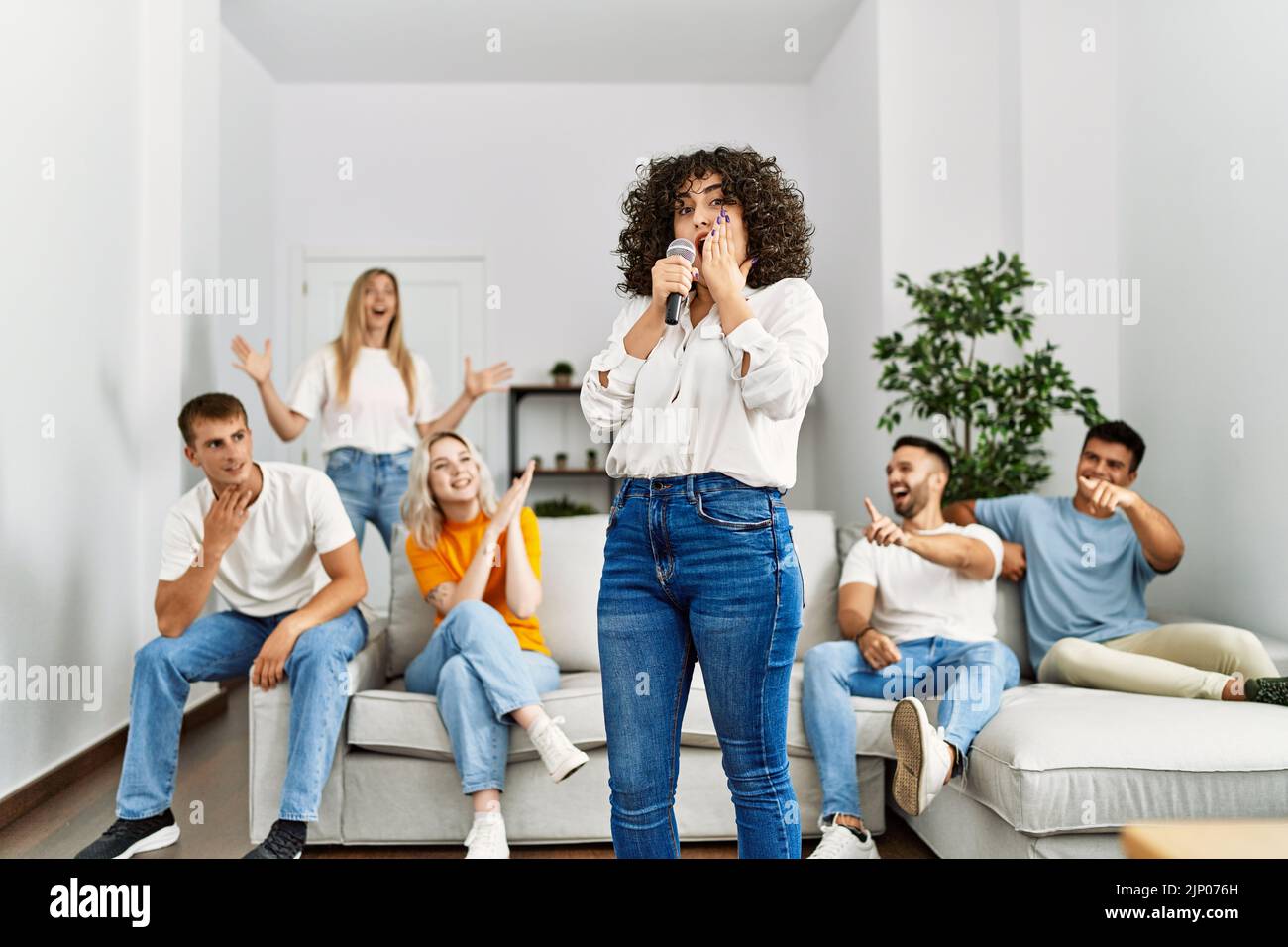 Group of young friends having party singing song using microphone at ...