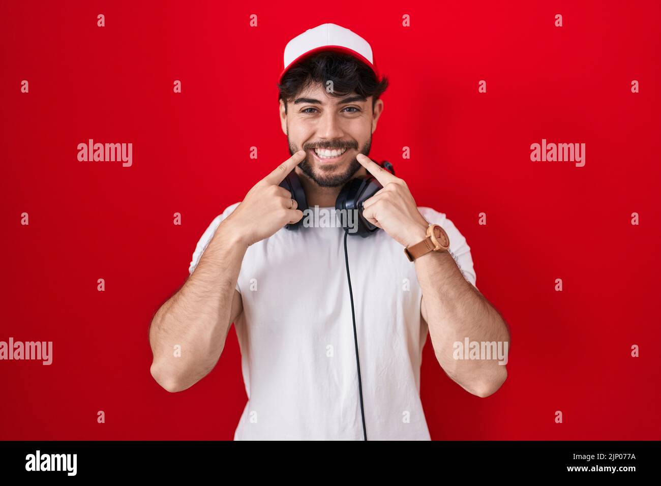 Hispanic man with beard wearing gamer hat and headphones smiling with ...