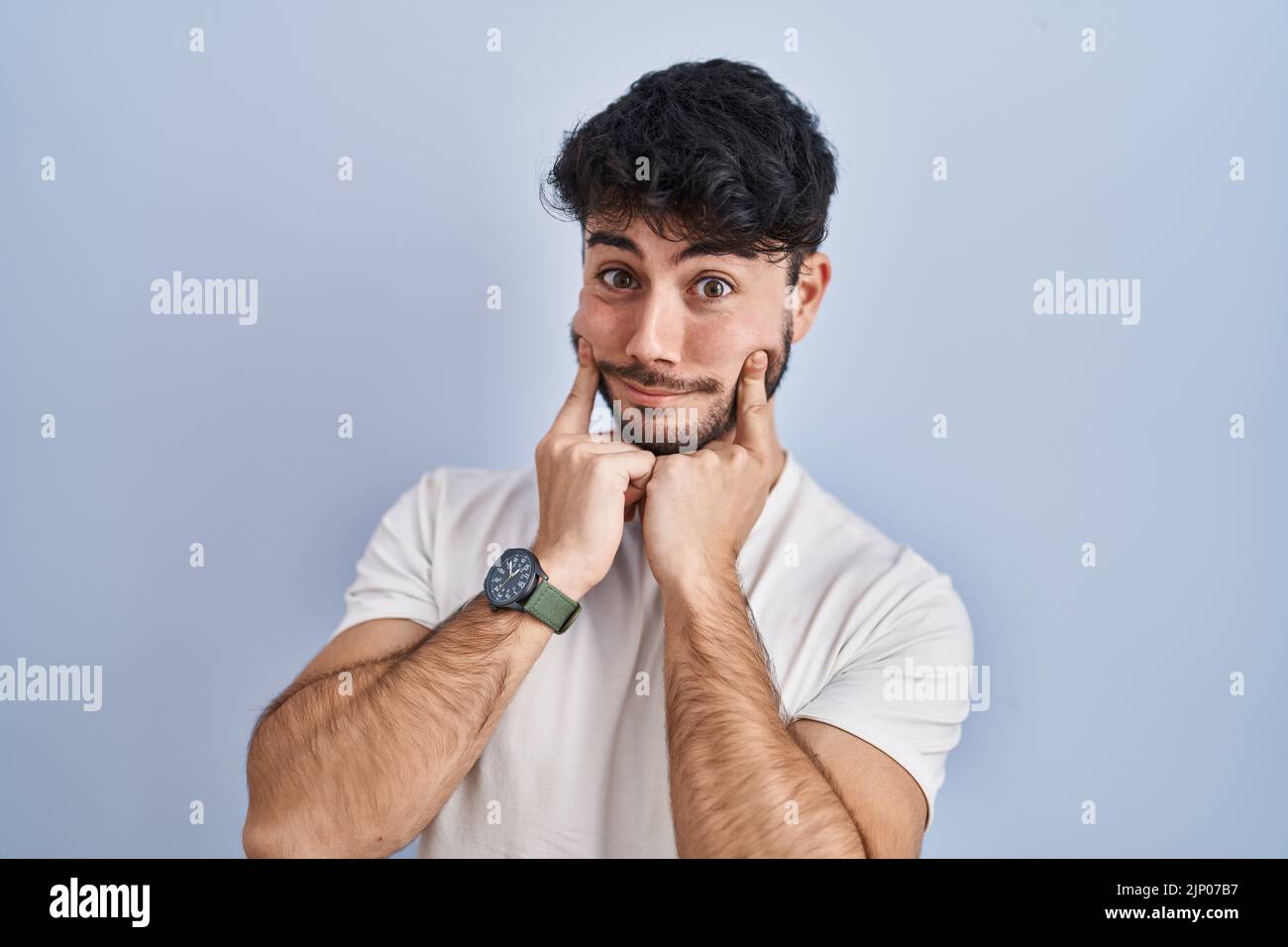 Hispanic man with beard standing over white background smiling with ...