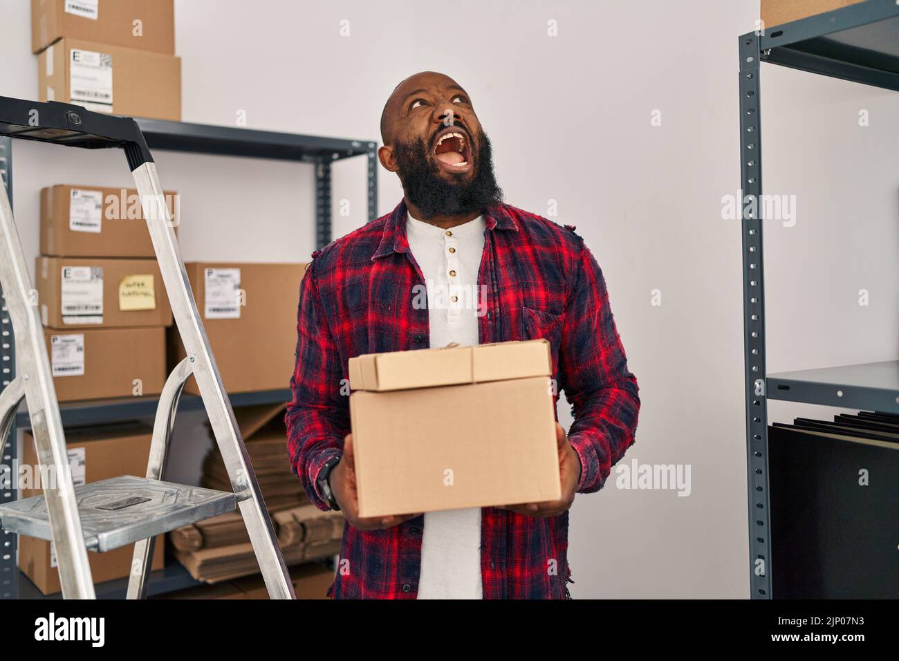African american man working at small business ecommerce angry and mad ...