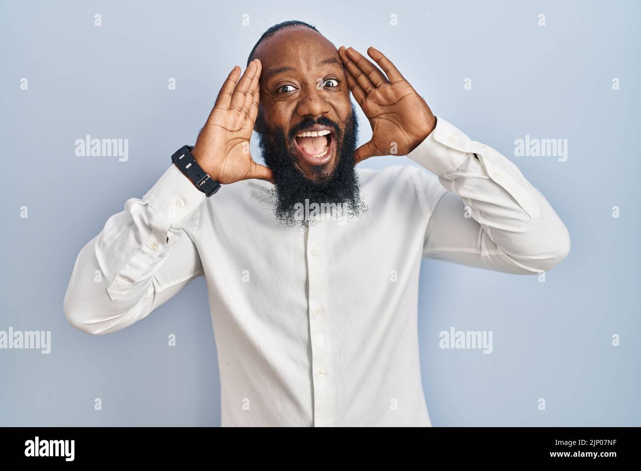 African american man standing over blue background smiling cheerful ...