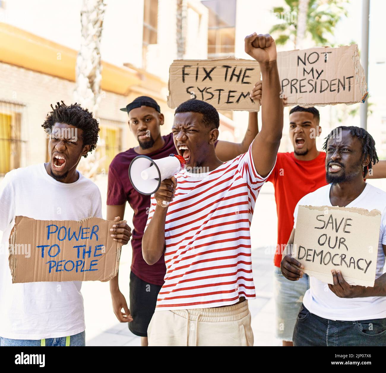 Group of young african american activists protesting holding banner and ...