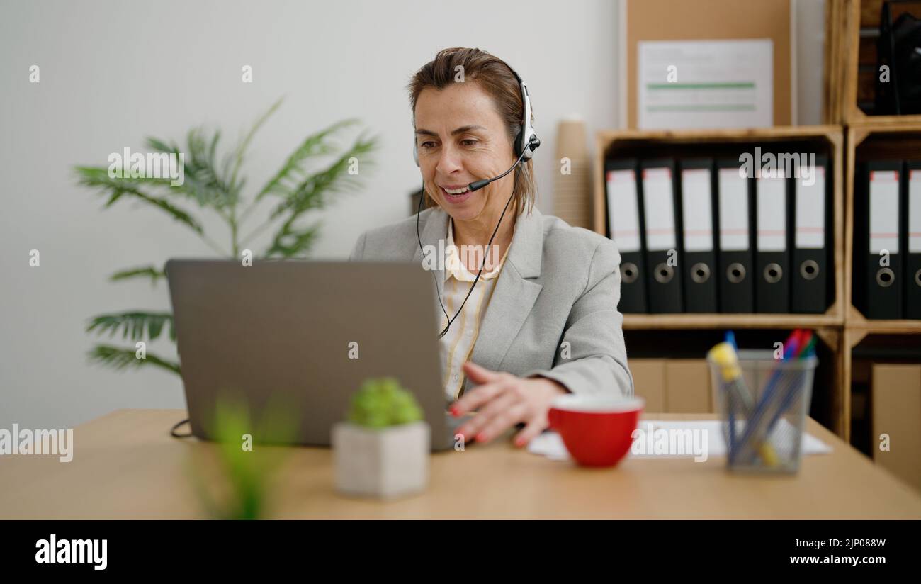 Middle age hispanic woman call center agent having video call at office ...