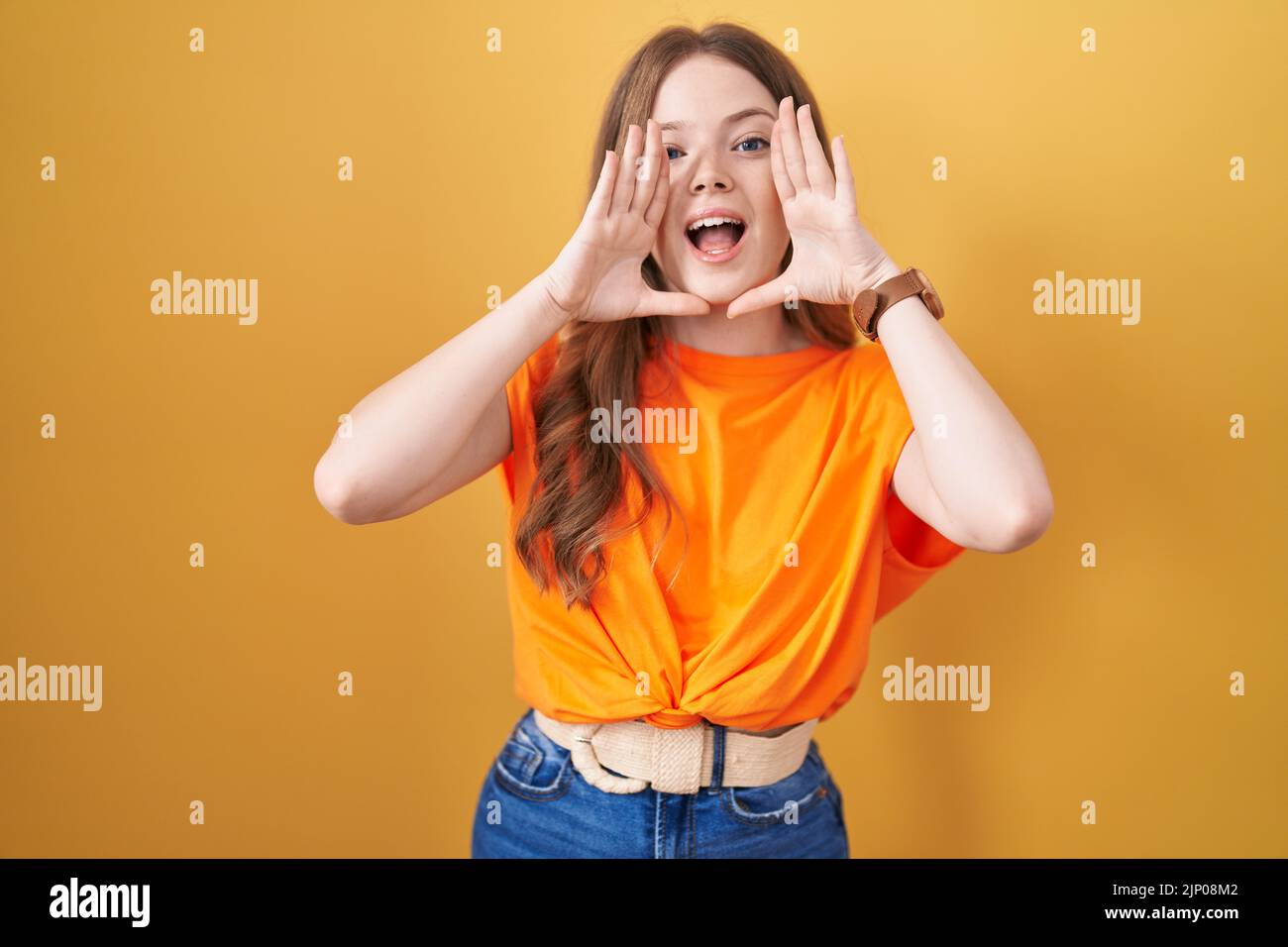 Caucasian woman standing over yellow background smiling cheerful ...