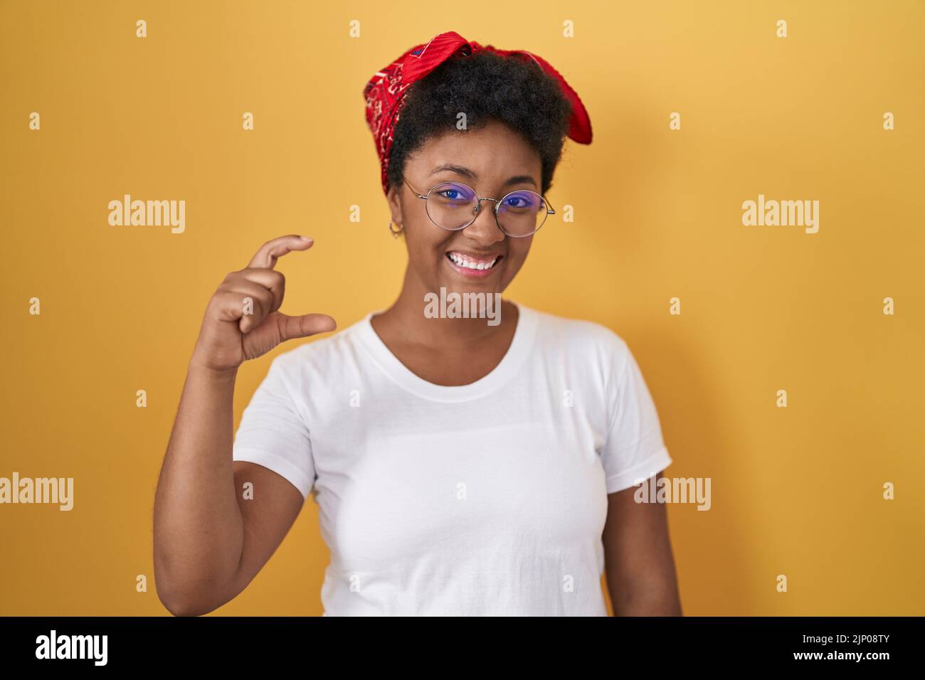 Young african american woman standing over yellow background smiling ...