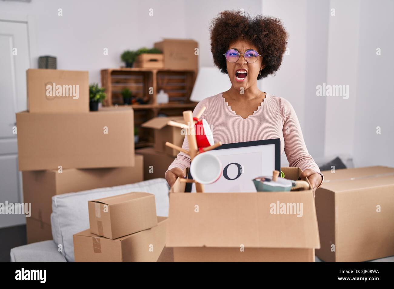 Young african american woman moving to a new home angry and mad ...