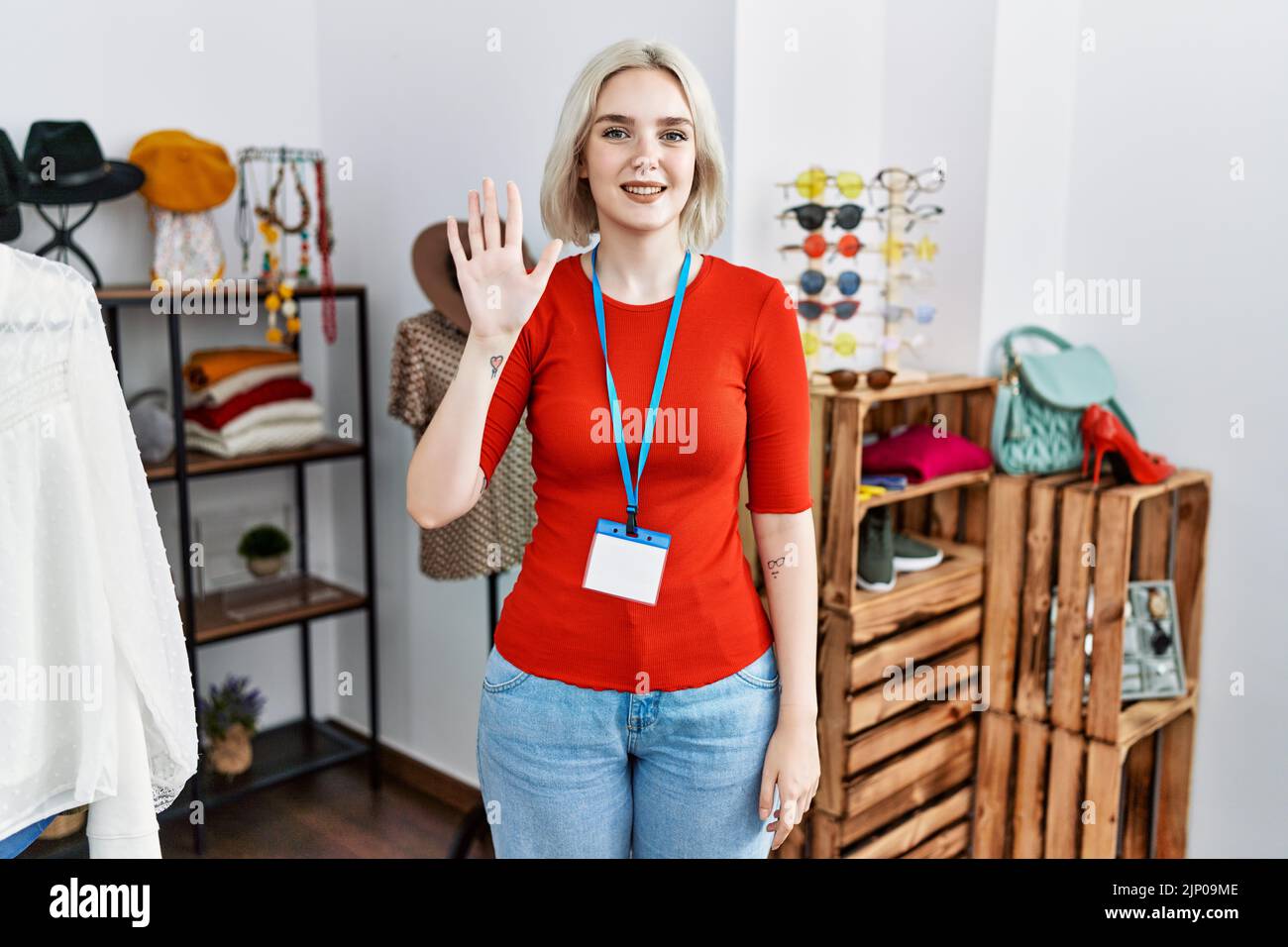 Young caucasian woman working as manager at retail boutique showing and ...