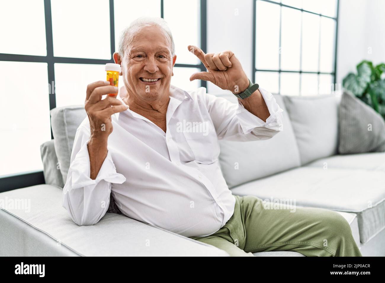 Senior man holding pills smiling and confident gesturing with hand ...