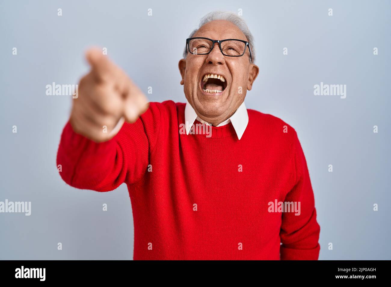 Senior man with grey hair standing over isolated background pointing ...