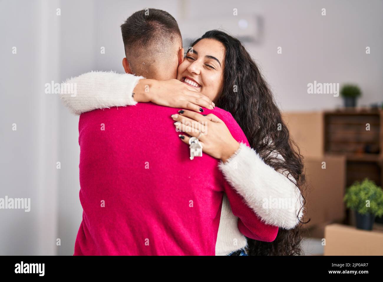 Man and woman couple hugging each other holding key at new home Stock ...