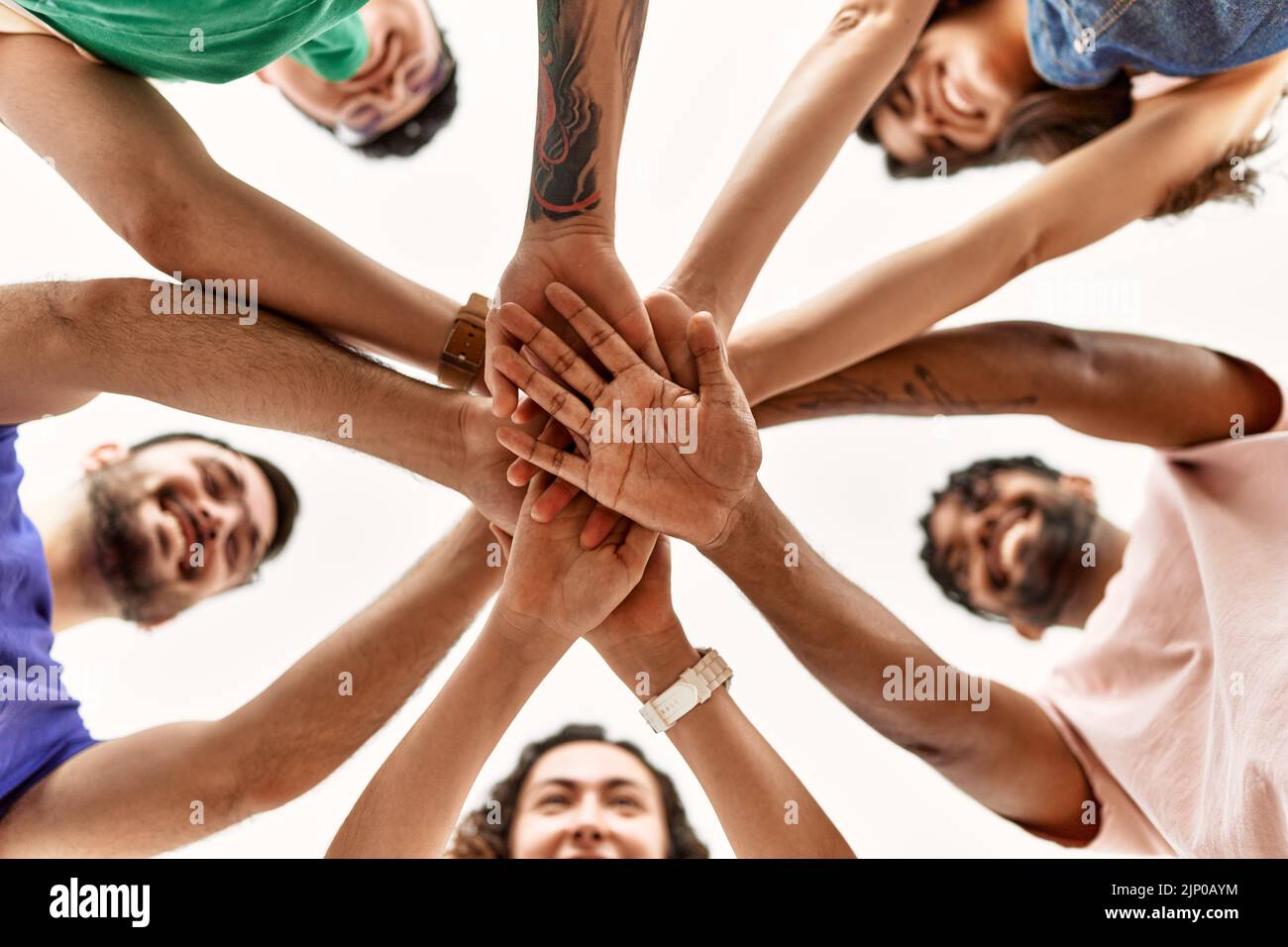 Group of young friends with hands together Stock Photo - Alamy