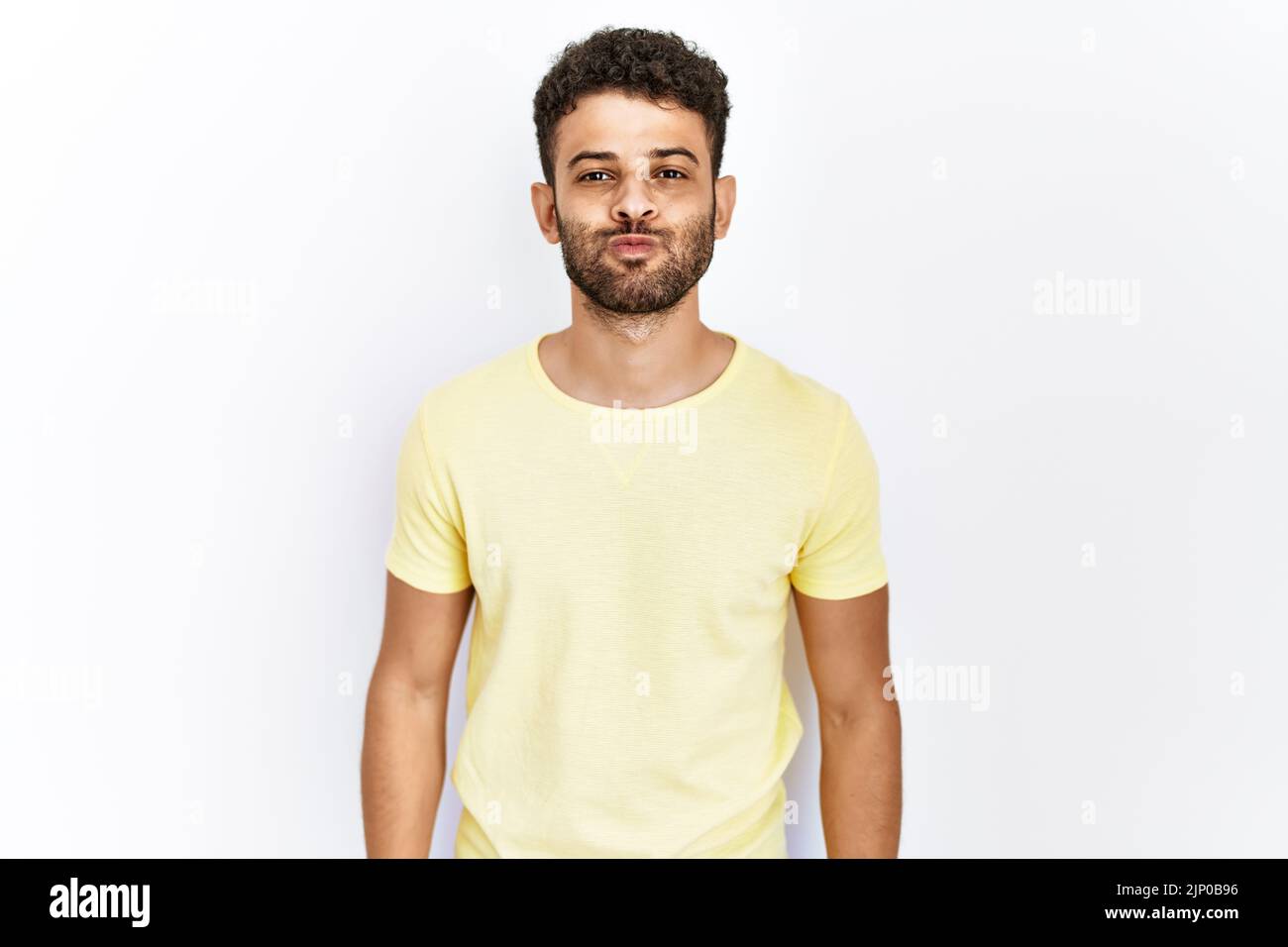Arab young man standing over isolated background puffing cheeks with ...