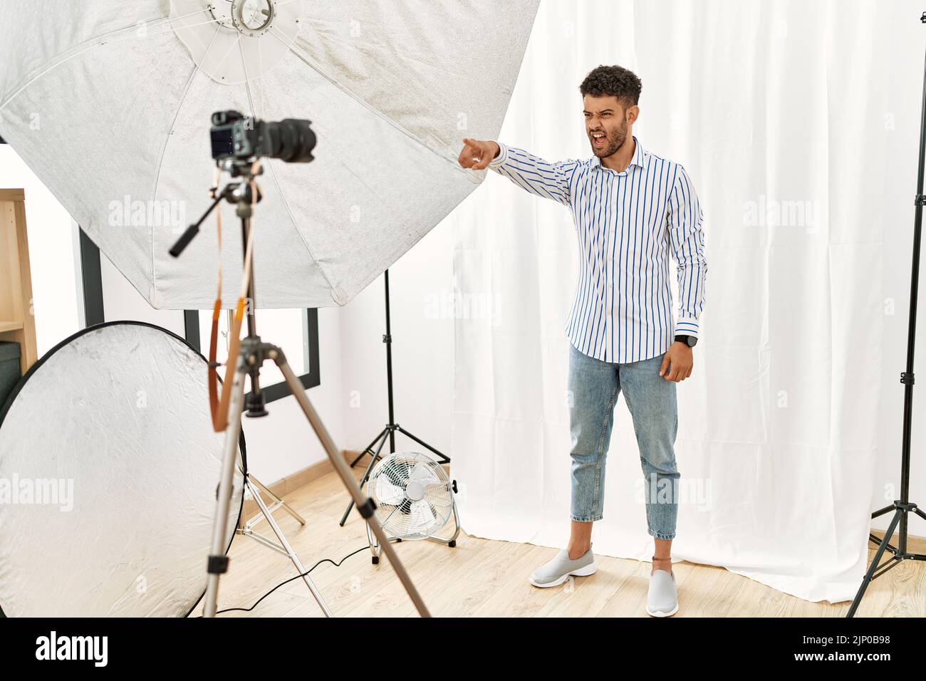 Arab young man posing as model at photography studio pointing ...