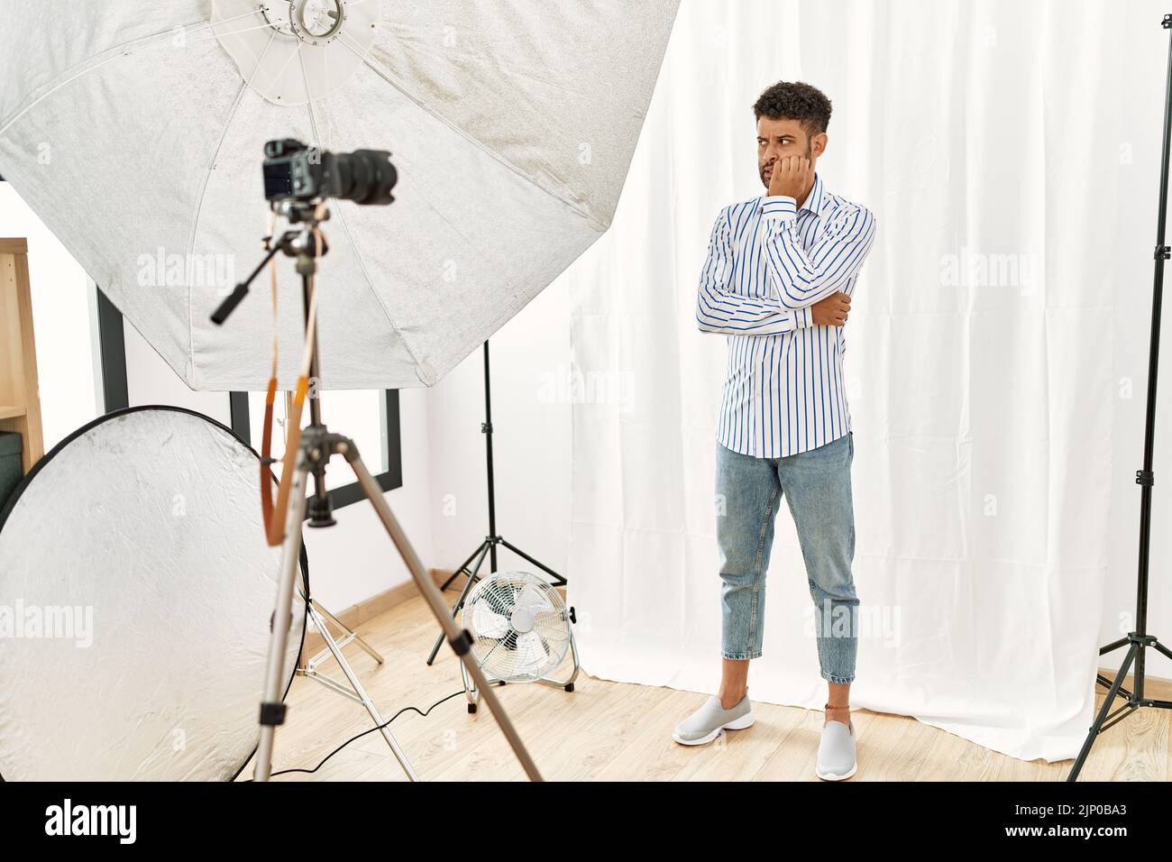 Arab young man posing as model at photography studio looking stressed ...