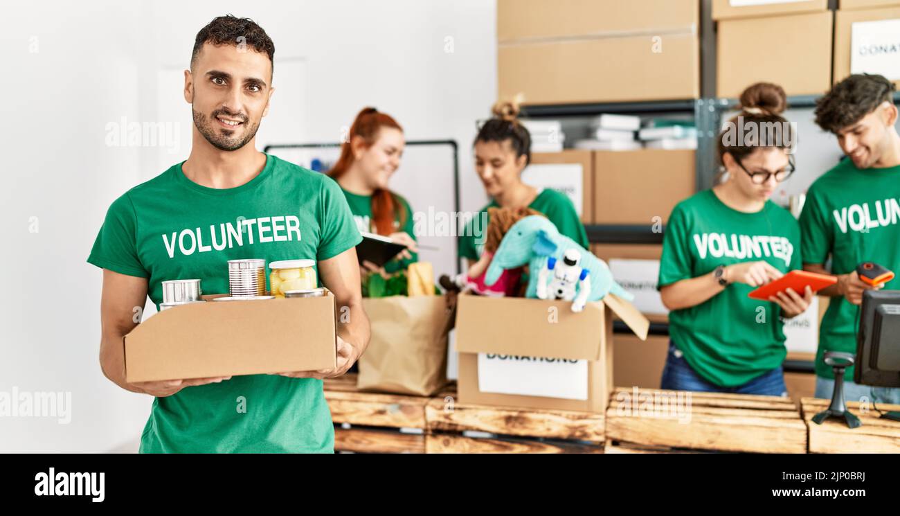Group of young volunteers working at charity center. Man smiling happy ...