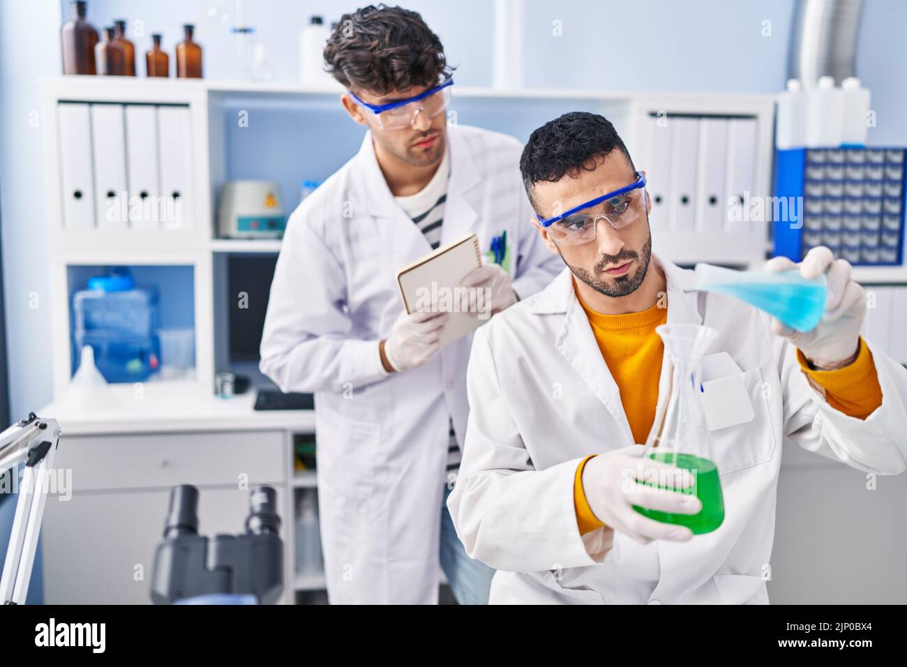 Two man scientists measuring liquid at laboratory Stock Photo - Alamy