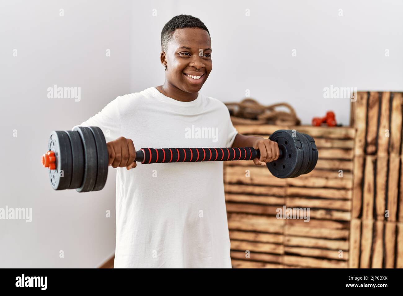 Young african man training with dumbbells at the gym Stock Photo - Alamy