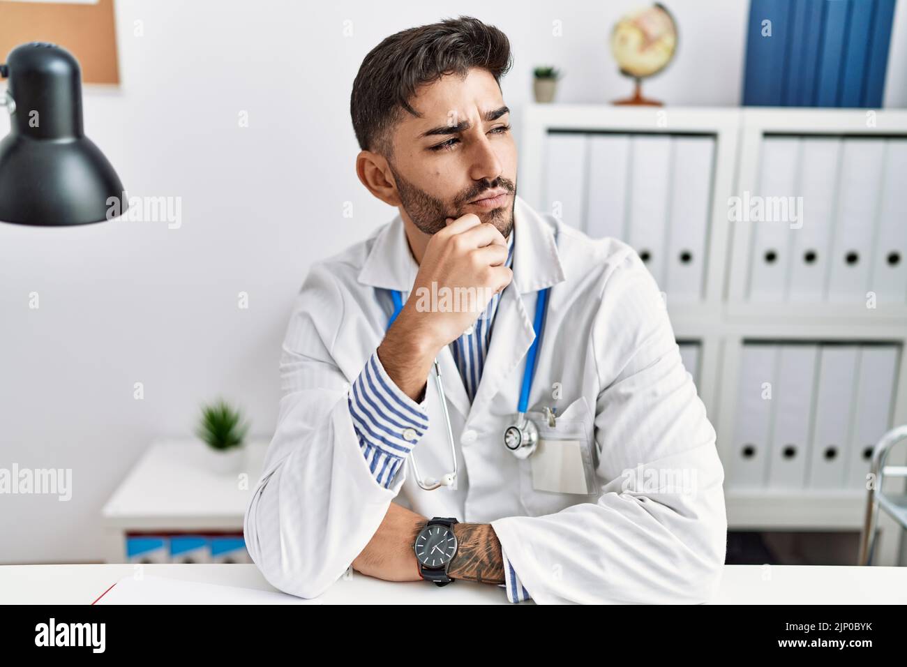 Handsome hispanic man working as doctor at medical consultation Stock ...