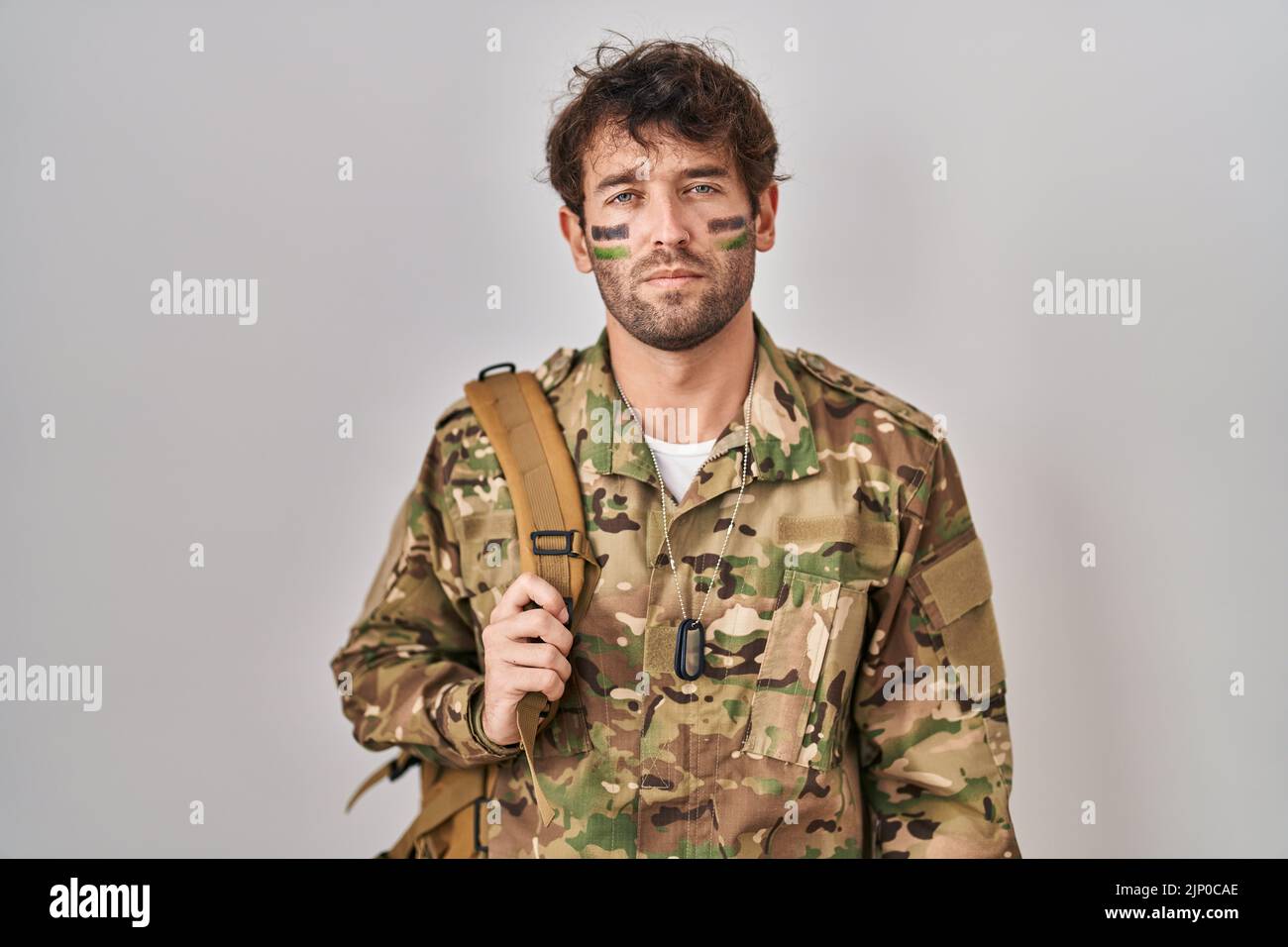 Hispanic young man wearing camouflage army uniform skeptic and nervous ...