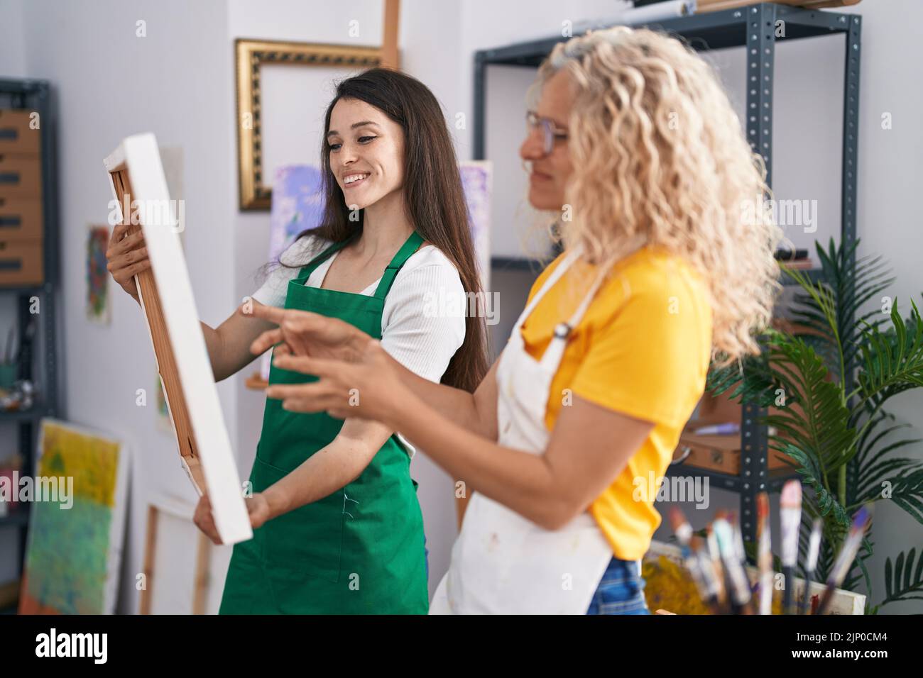 Two women artists smiling confident holding draw at art studio Stock ...