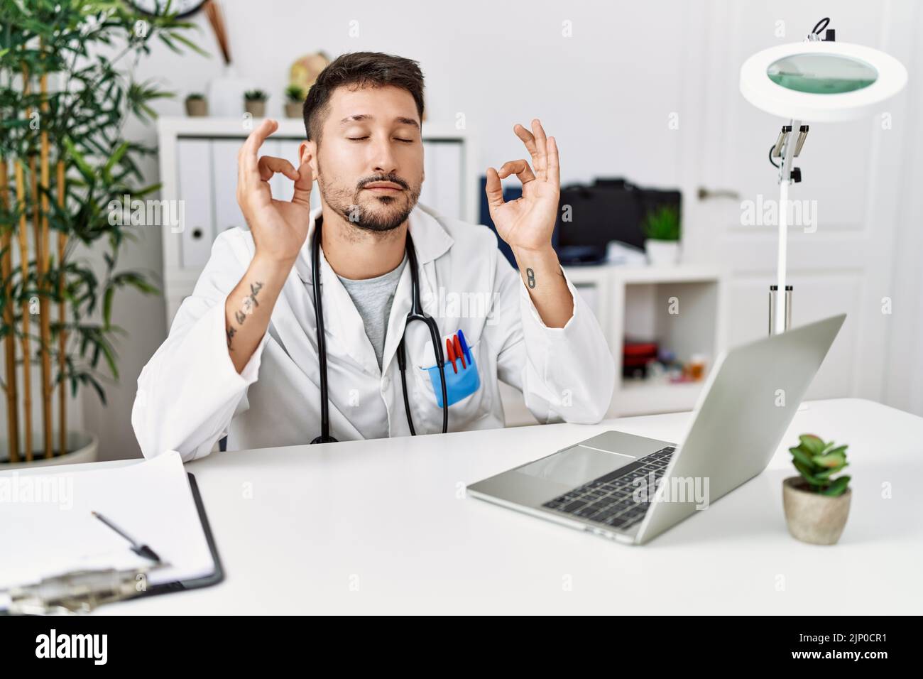 Young doctor working at the clinic using computer laptop relax and ...