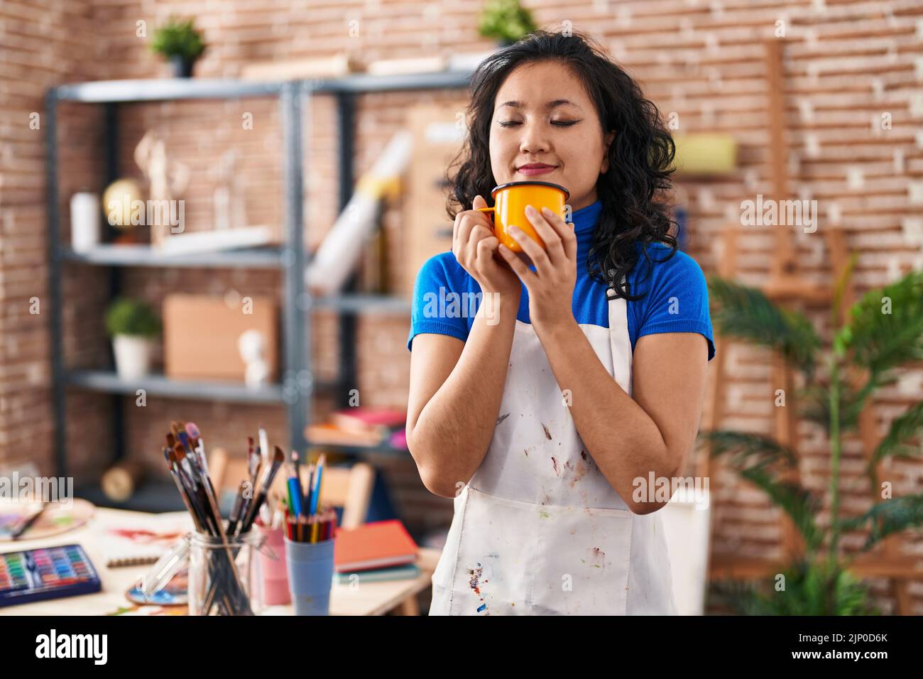 Young chinese woman artist drinking coffee at art studio Stock Photo ...