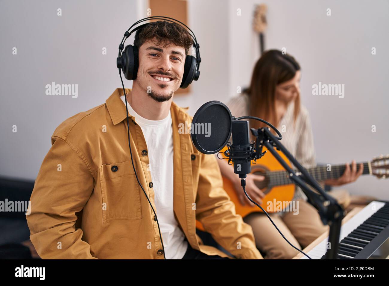 Mand and woman musicians singing song playing classical guitar at music ...