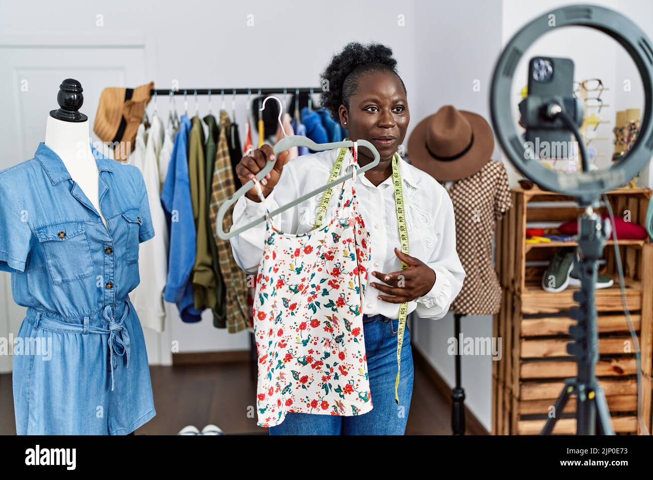 Young african american woman shopkeeper selling clothes online at ...