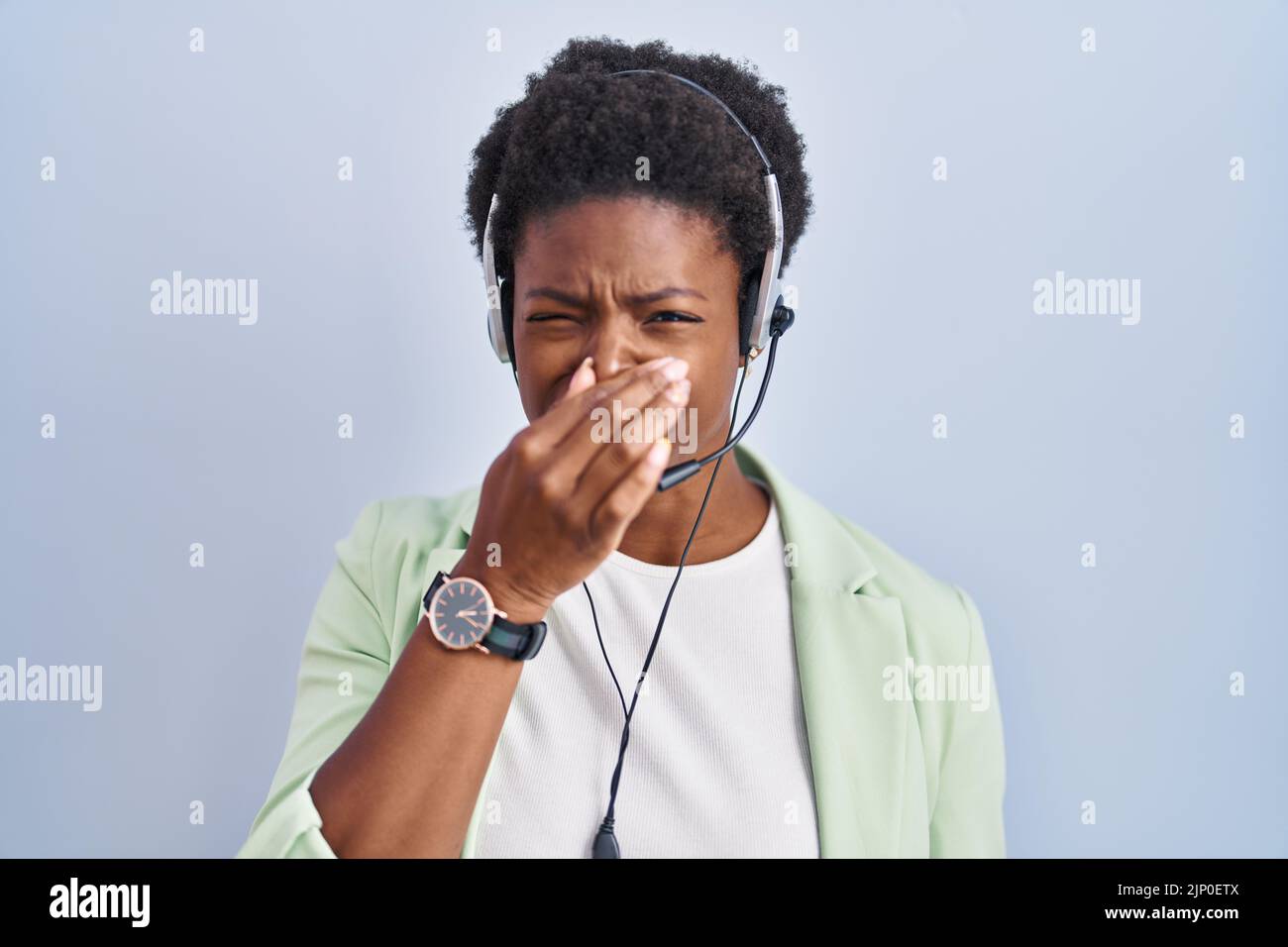 African american woman wearing call center agent headset smelling ...
