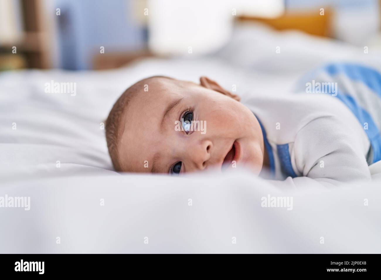 Adorable baby relaxed lying on bed at bedroom Stock Photo - Alamy