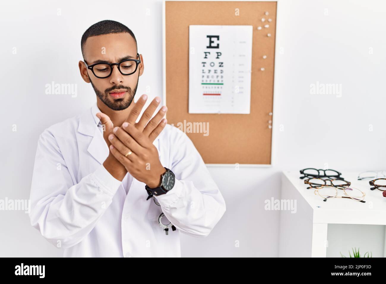 African american optician man standing by eyesight test suffering pain ...
