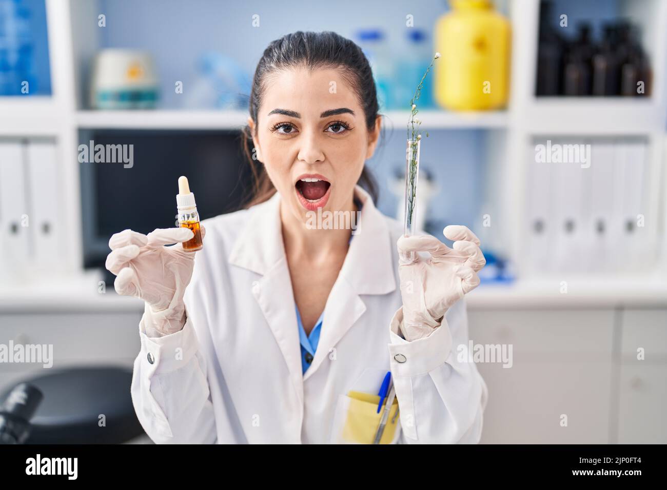 Young woman doing weed oil extraction at laboratory afraid and shocked ...