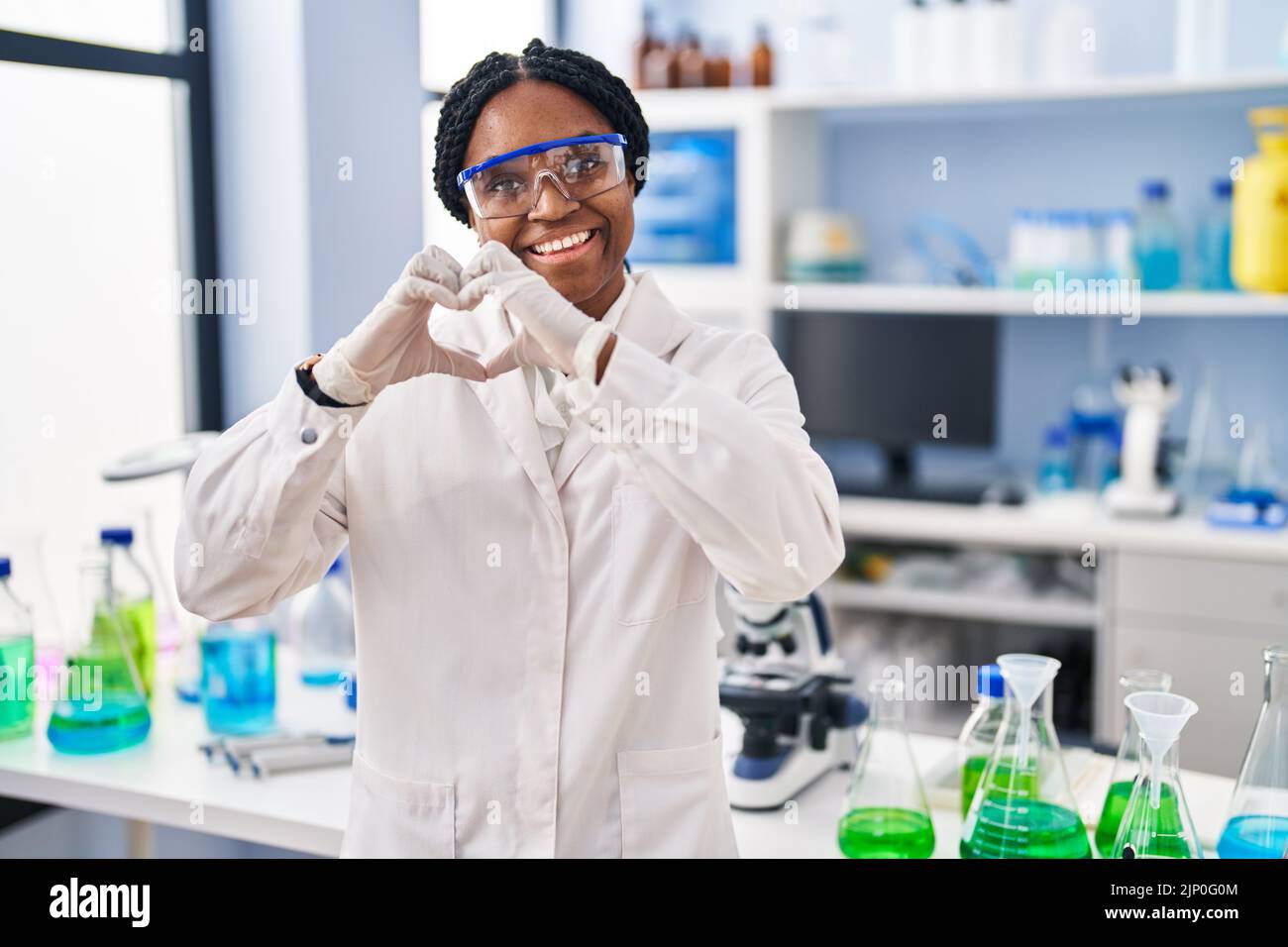African american woman working at scientist laboratory smiling in love ...
