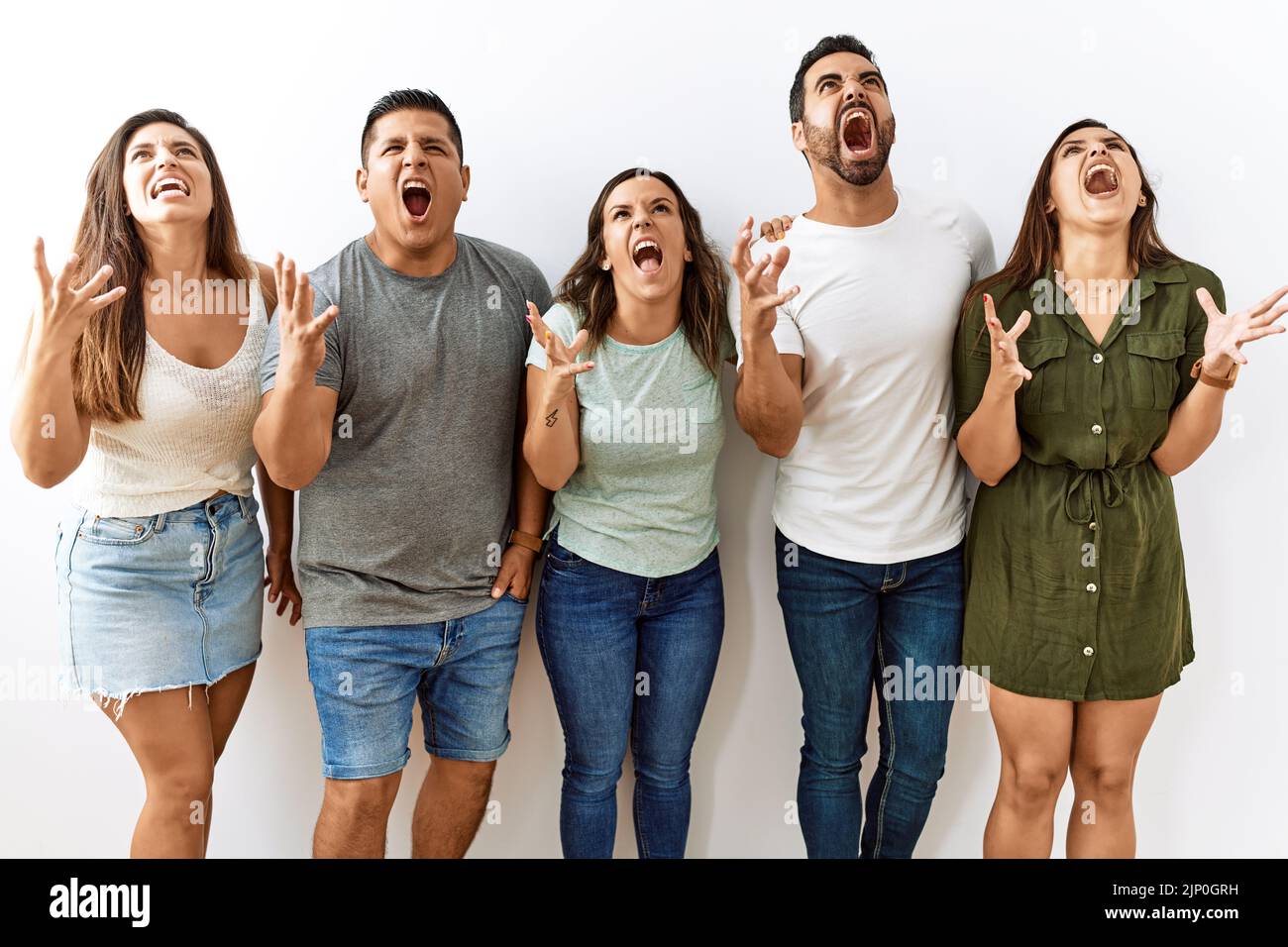 Group of young hispanic friends standing together over isolated ...
