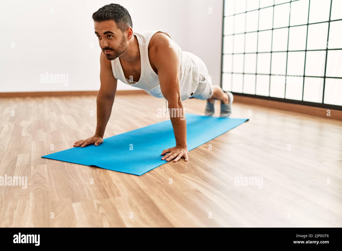 Young hispanic man training abs exercise at sport center Stock Photo ...