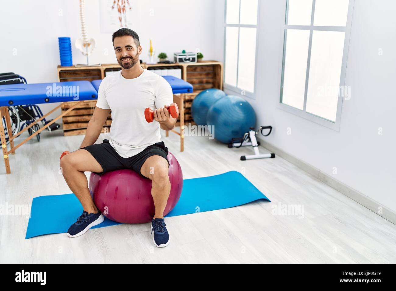 Young hispanic man patient smiling confident having rehab session using ...