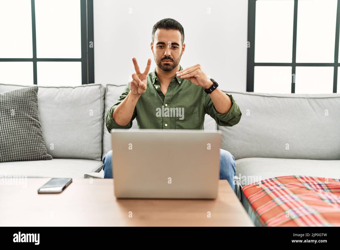 Young hispanic man having video call speaking with deaf language at ...
