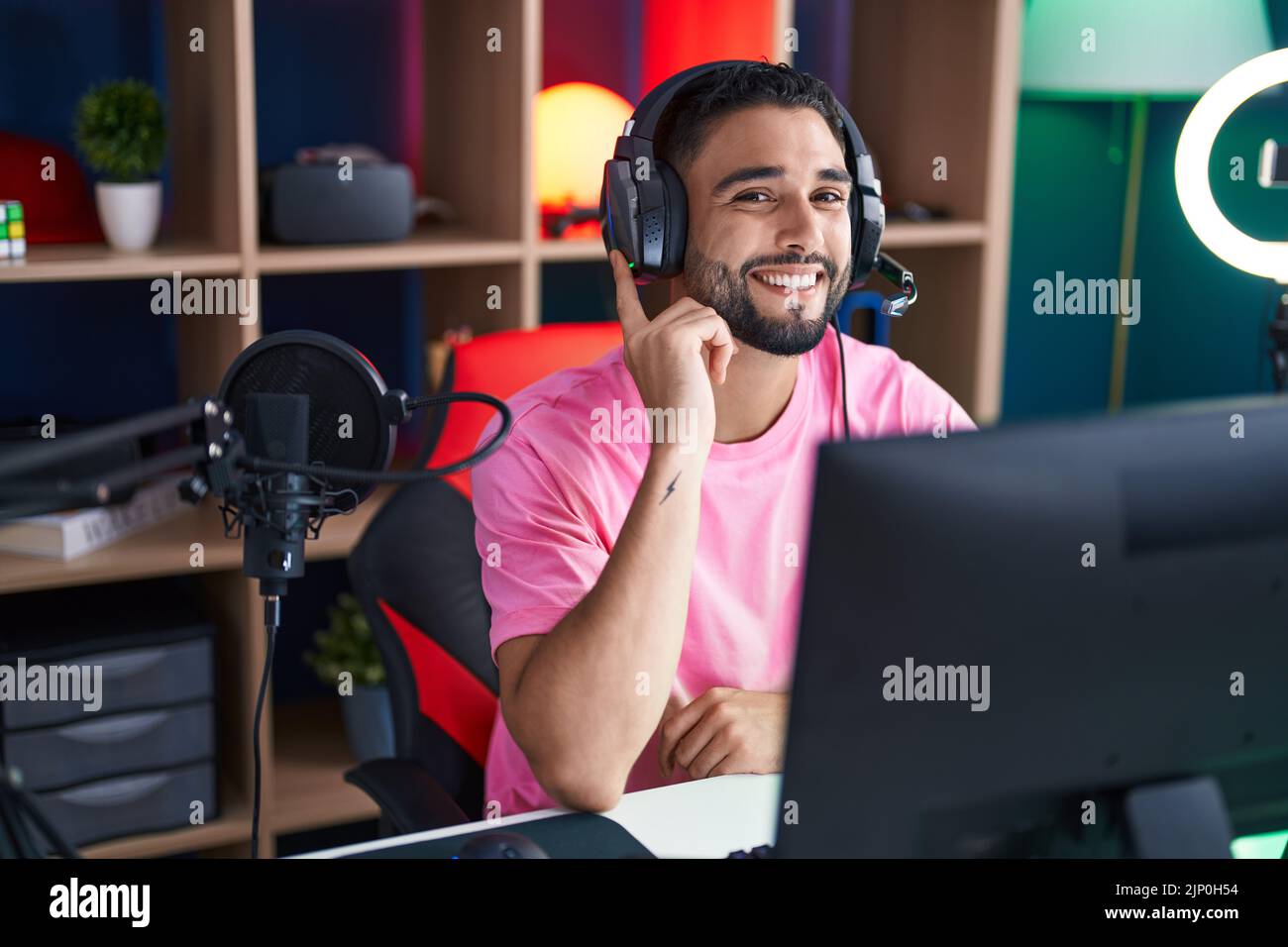 Young arab man streamer smiling confident sitting on table at gaming ...