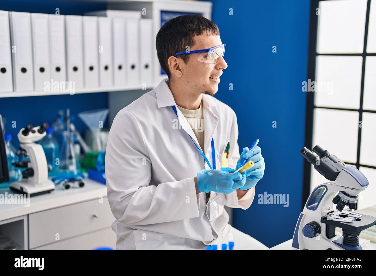 Young man scientist writing on test tube at laboratory Stock Photo - Alamy