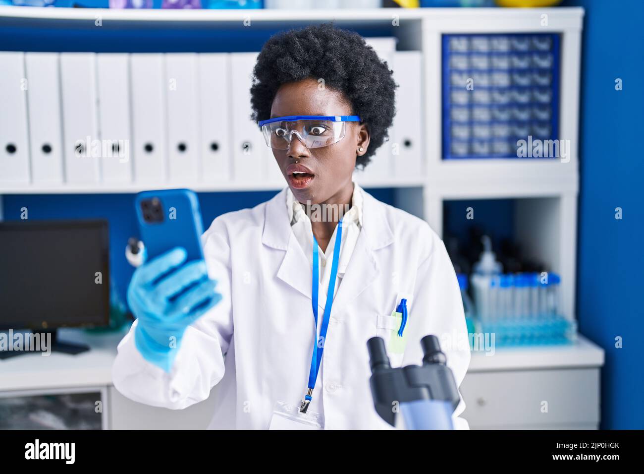 African young woman working at scientist laboratory doing video call ...