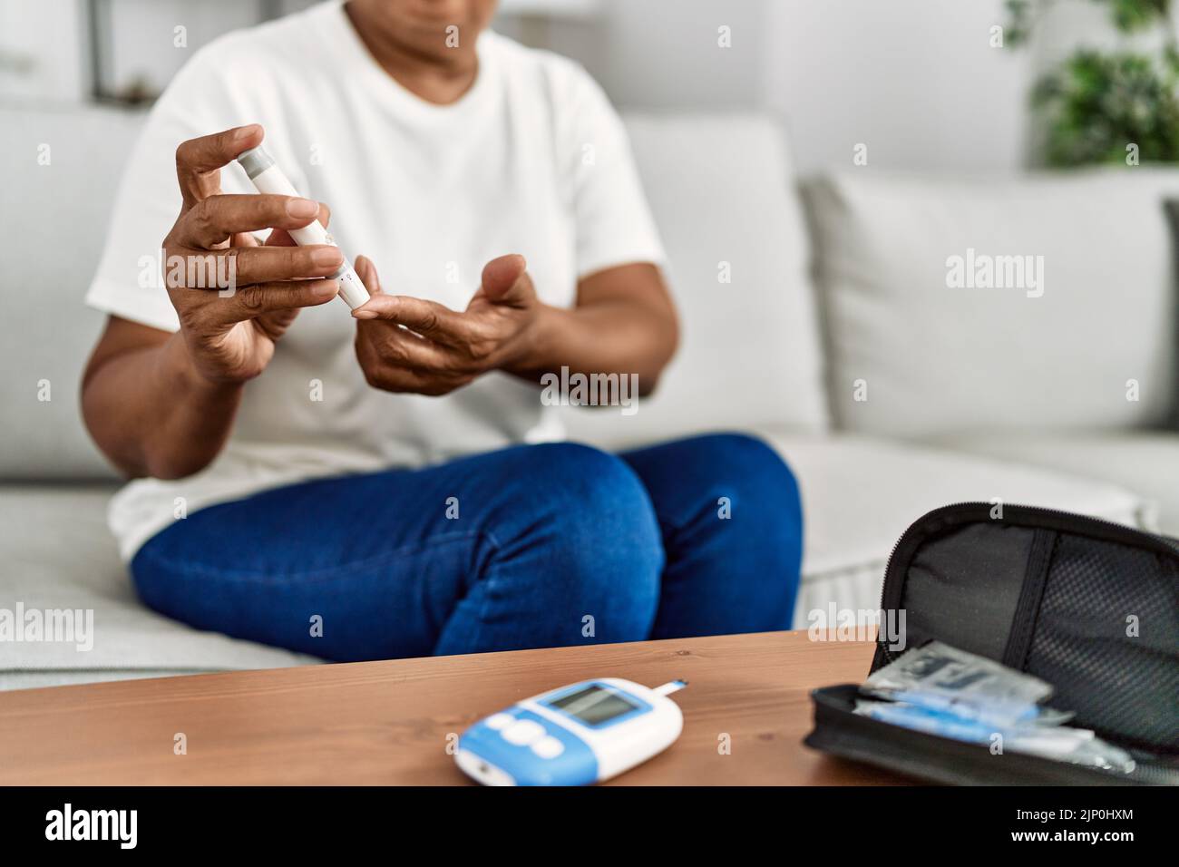 Senior african american woman measuring glucose at home Stock Photo - Alamy