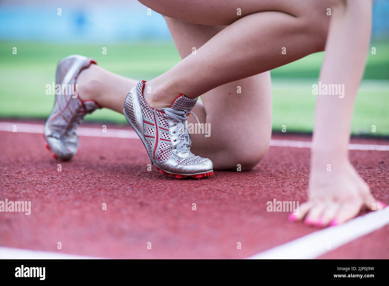 Close-up of female legs. The runner in the stadium is ready for the ...