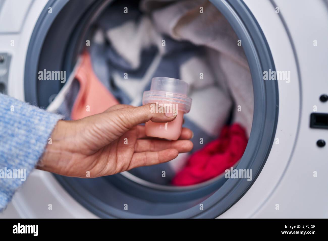 Hand pouring detergent on clothes hi-res stock photography and images ...